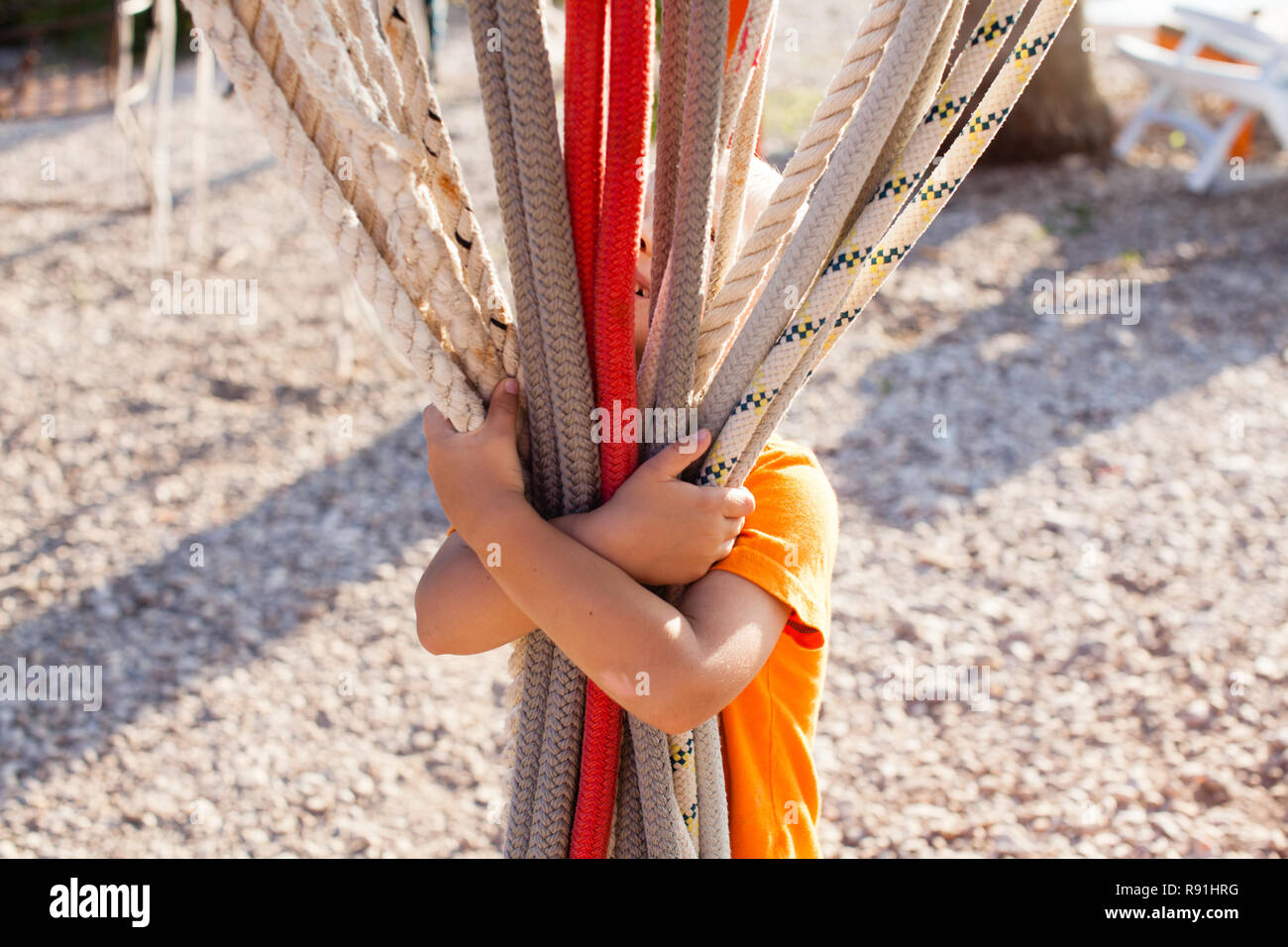 Boy holds many ropes on the marine playground Stock Photo - Alamy