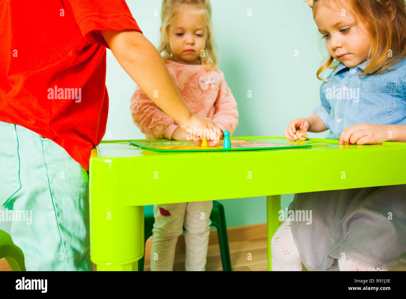 Portrait of two girls sitting at the kids table Stock Photo - Alamy