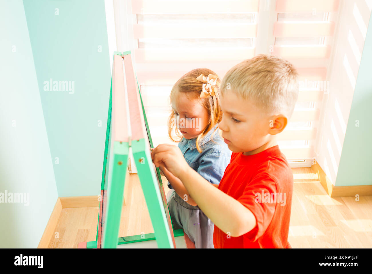 Little kids drawing with chalk on the blackboard Stock Photo - Alamy