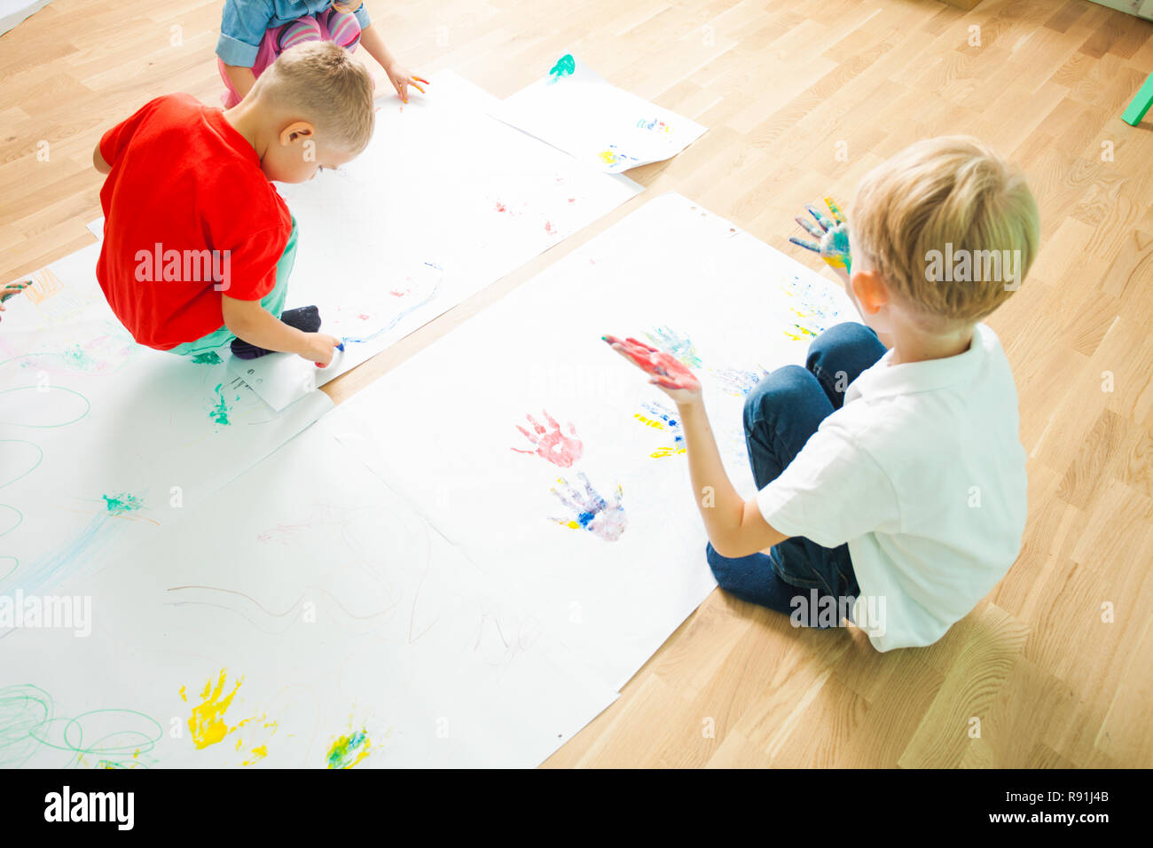 Top view of two kids drawing on a floor Stock Photo - Alamy
