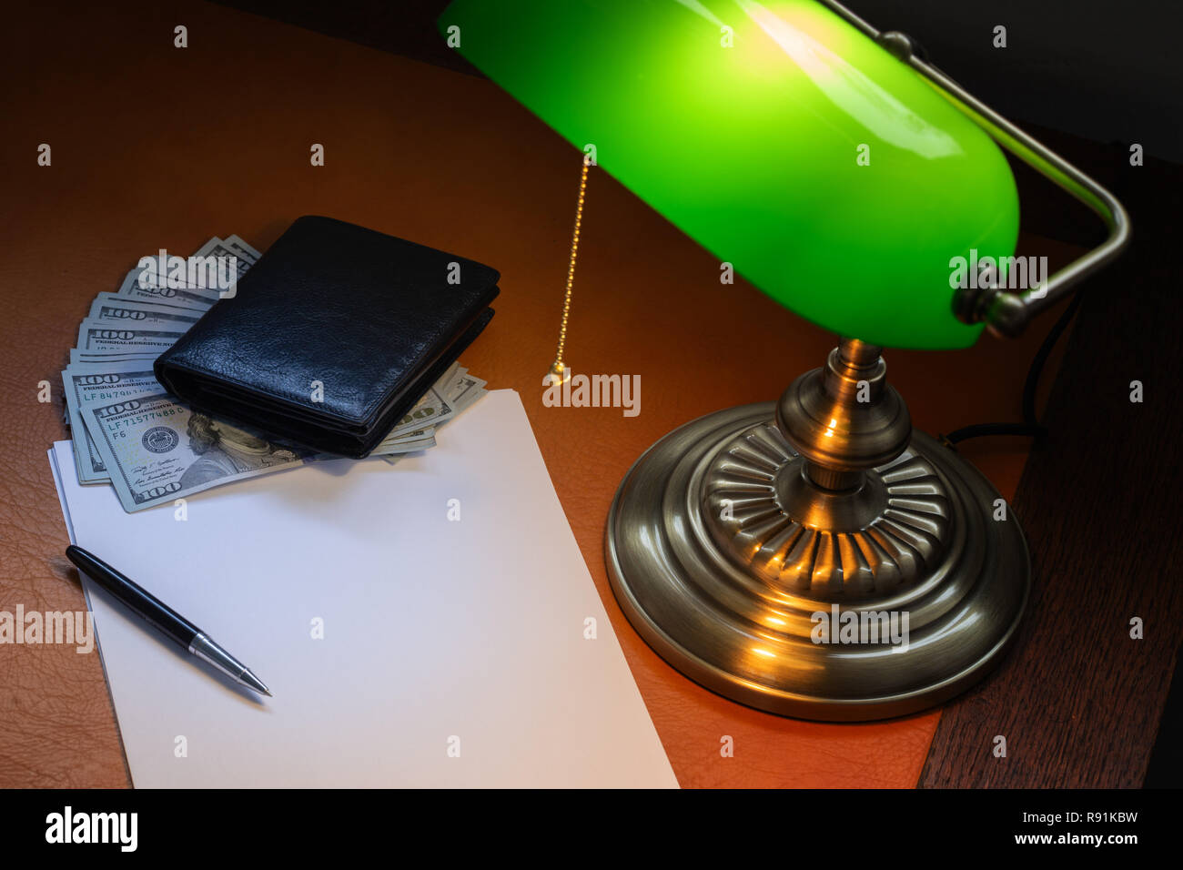 American dollars, on a stylish desk lit with a banking lamp Stock Photo ...