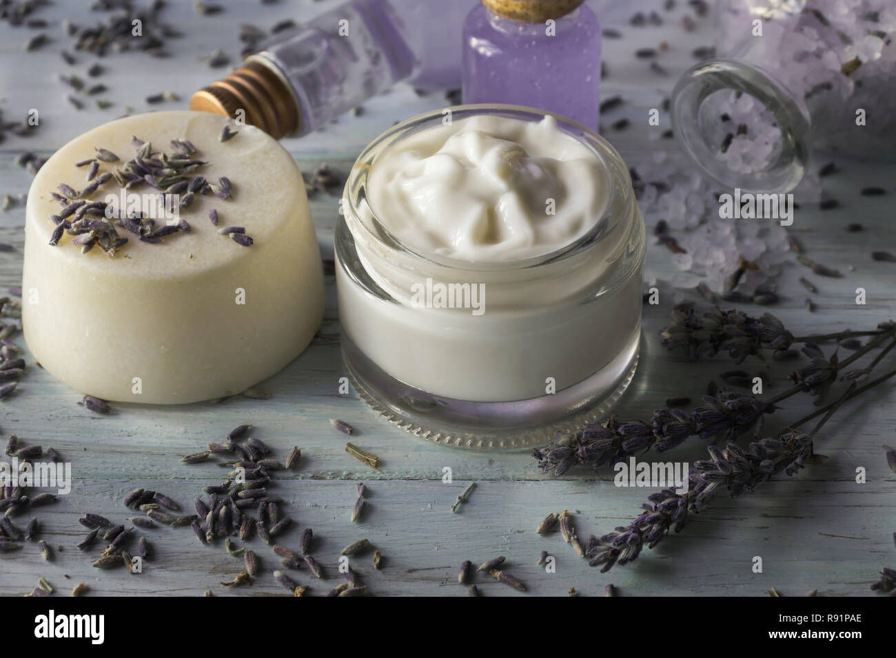 Homemade facial cream, soap, tonic and lavender bath salts, on a light ...