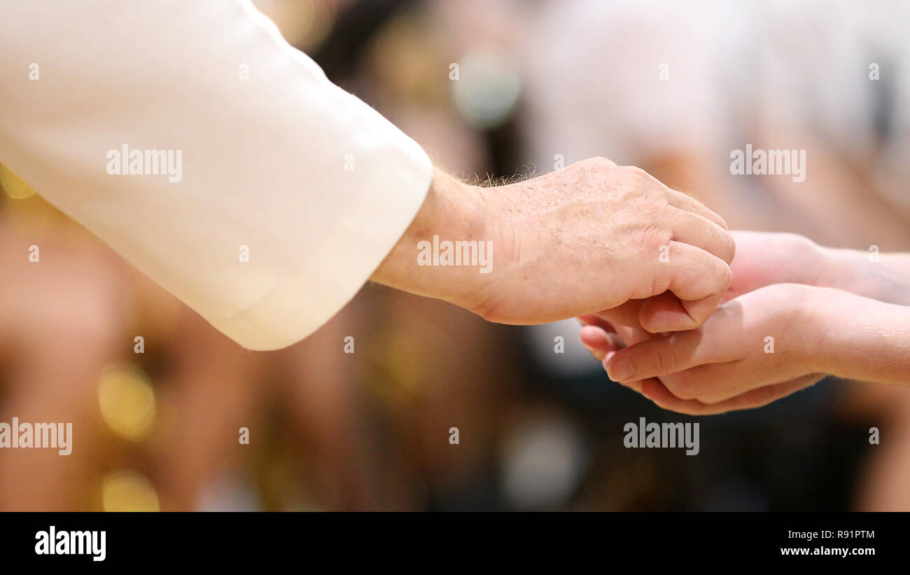 Close up image of a parishioners hands clasped receiving the bread ...