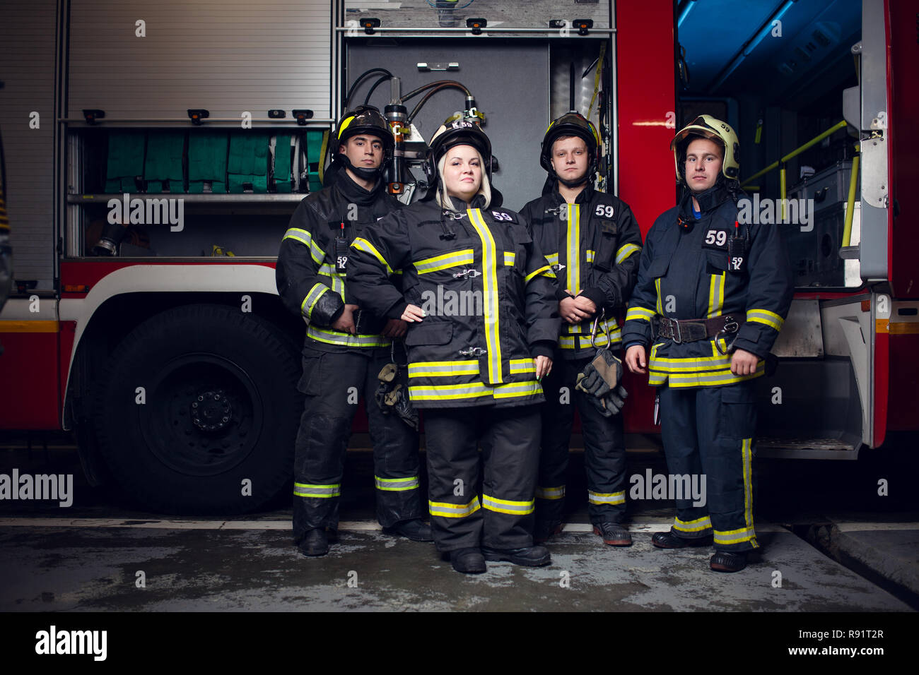 Full-length photo of three fire men and woman on background of fire ...