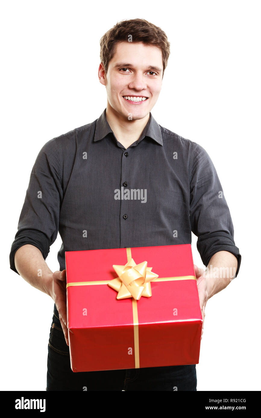 Holiday and special occasion. Young handsome man giving red present ...