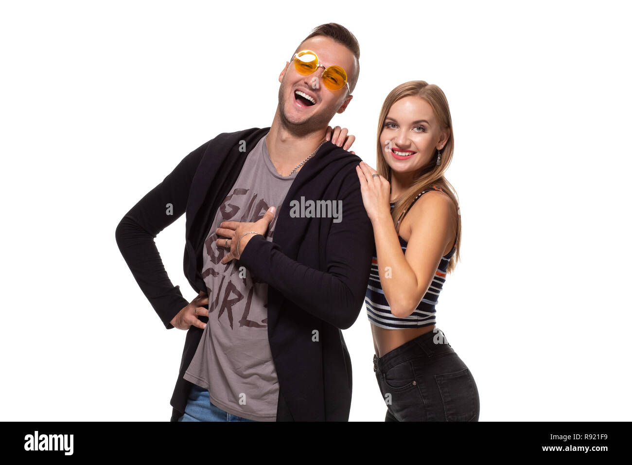 Happy young lovely couple standing together and laughing. Studio shot ...