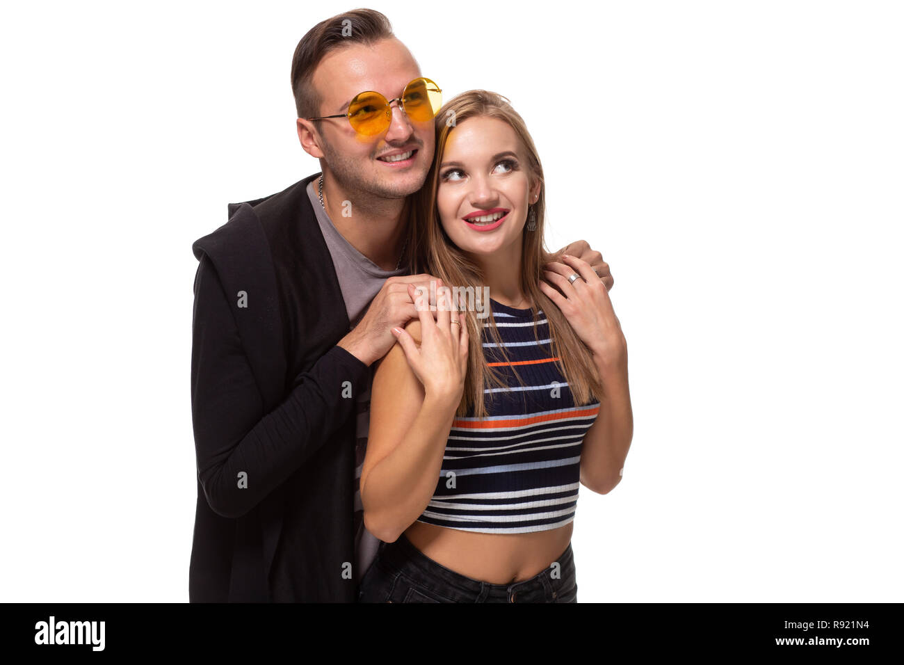 Happy young lovely couple standing together and laughing. Studio shot ...