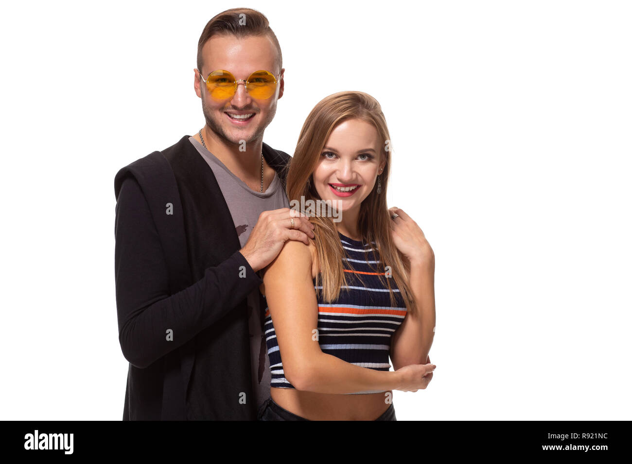Happy young lovely couple standing together and laughing. Studio shot ...
