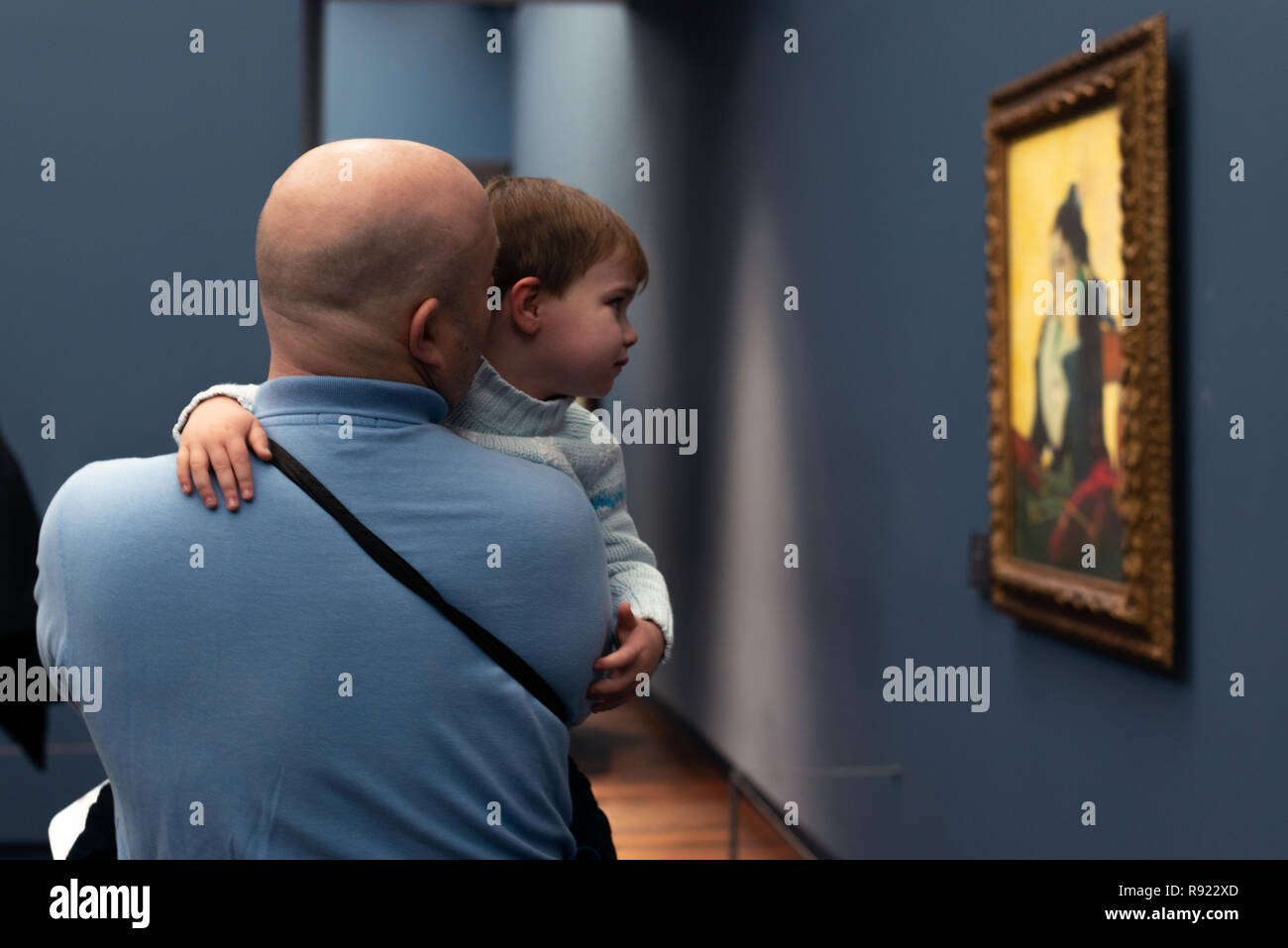 A baby and father look at a 'L'Arlesienne' by Vincent Van Gogh. Musee D ...
