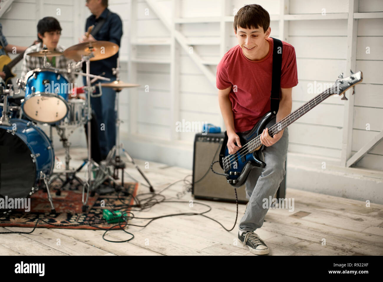 Teenage boy playing a bass guitar enthusiastically Stock Photo - Alamy