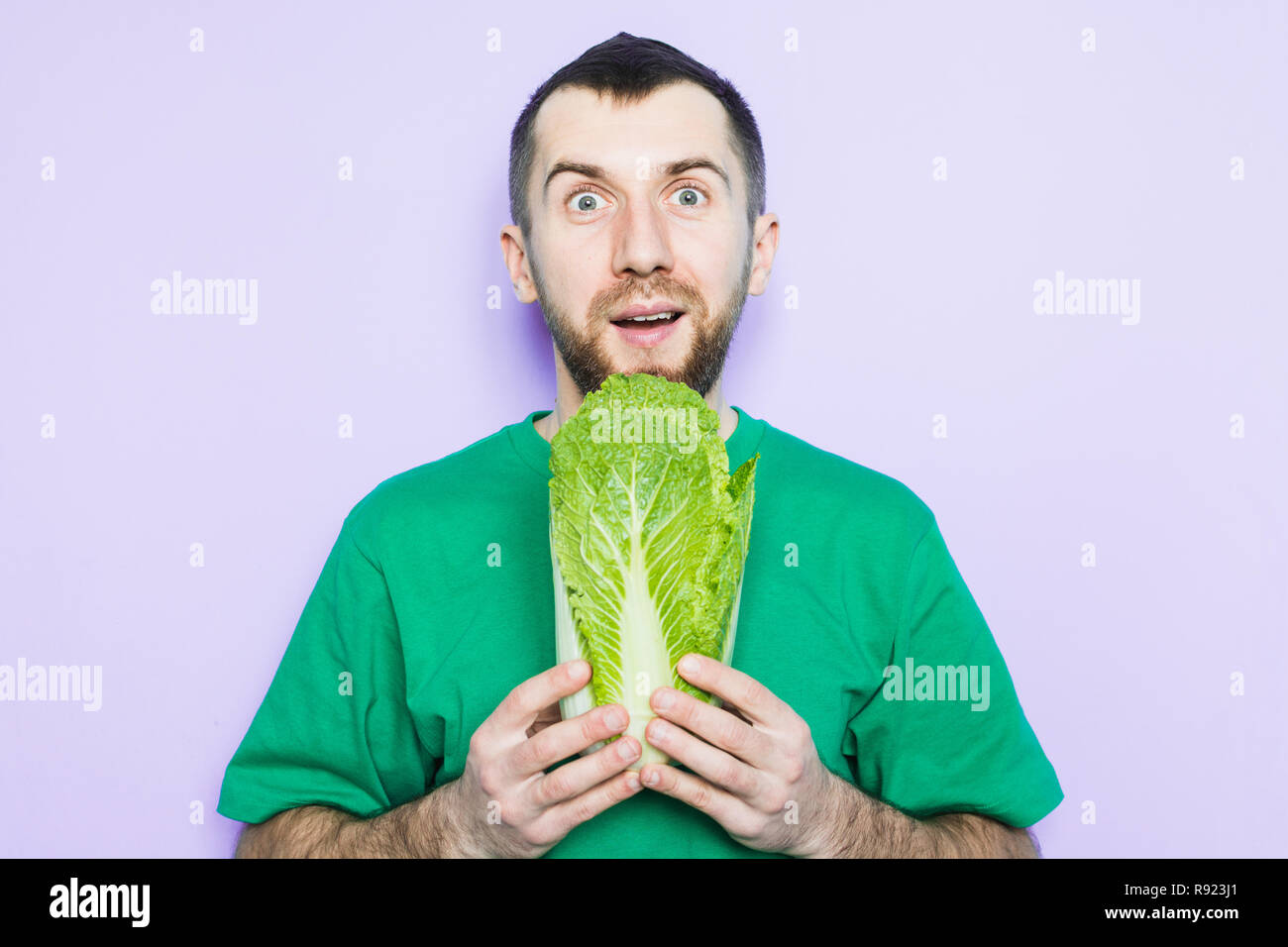 Young man holding Beijing napa cabbage in his hands, silly face ...