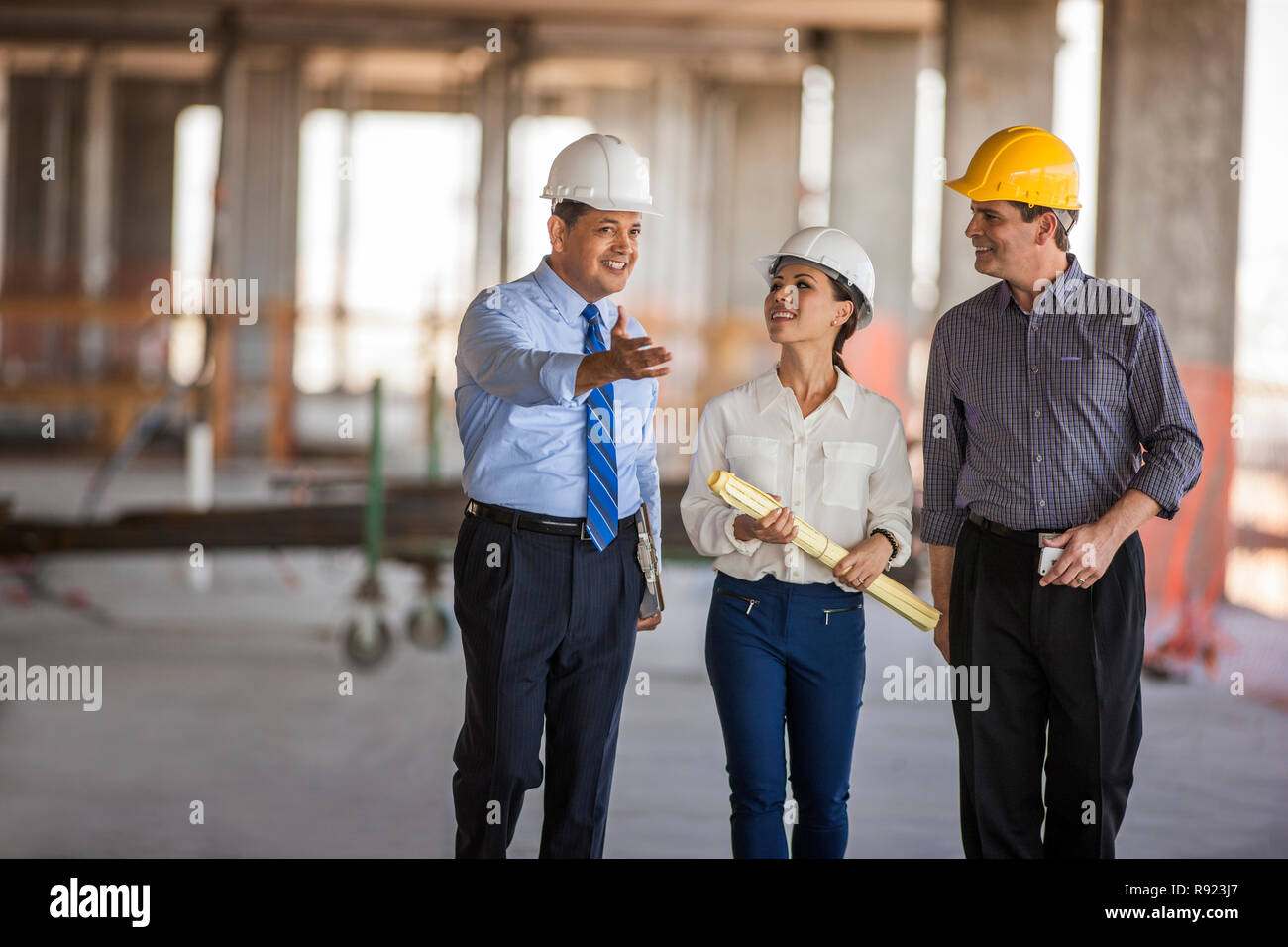 An architect and two executives talk on construction site Stock Photo ...
