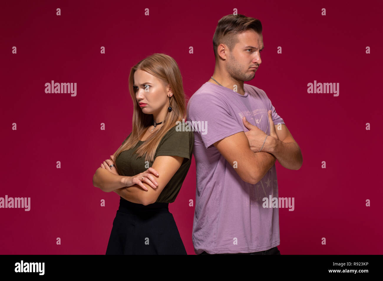 Studio portrait of a young couple in casual wear quarreled and taking a ...