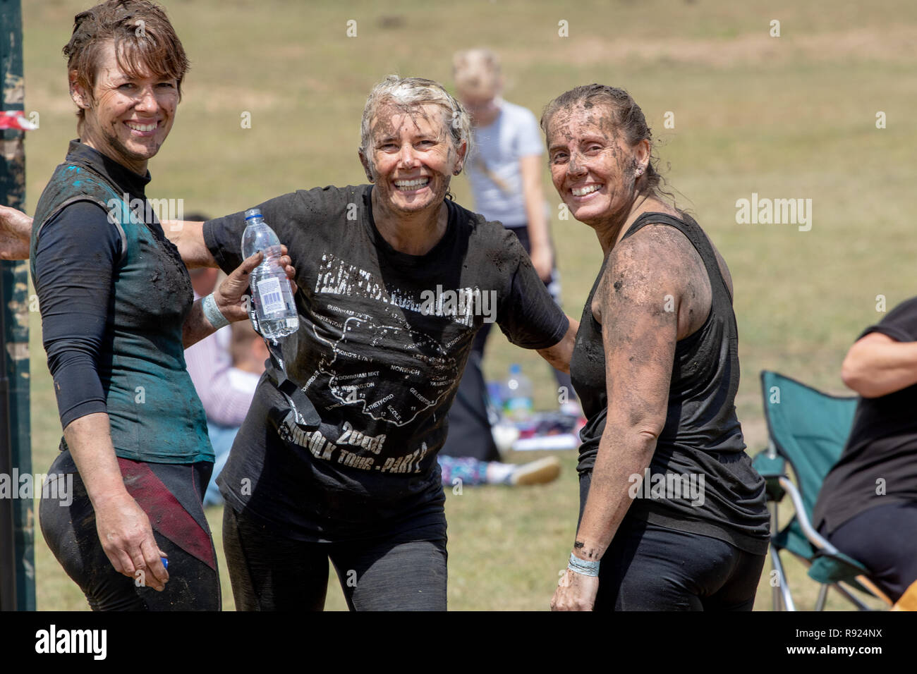 Muddy happy women having completed a mud run Stock Photo - Alamy