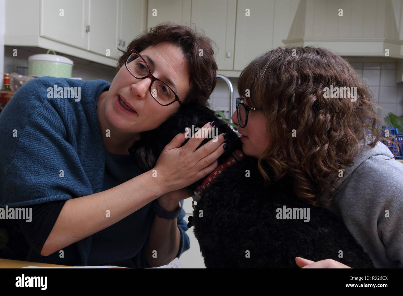 Mother and Daughter Hugging A Cockapoo Dog Surrey England Stock Photo ...