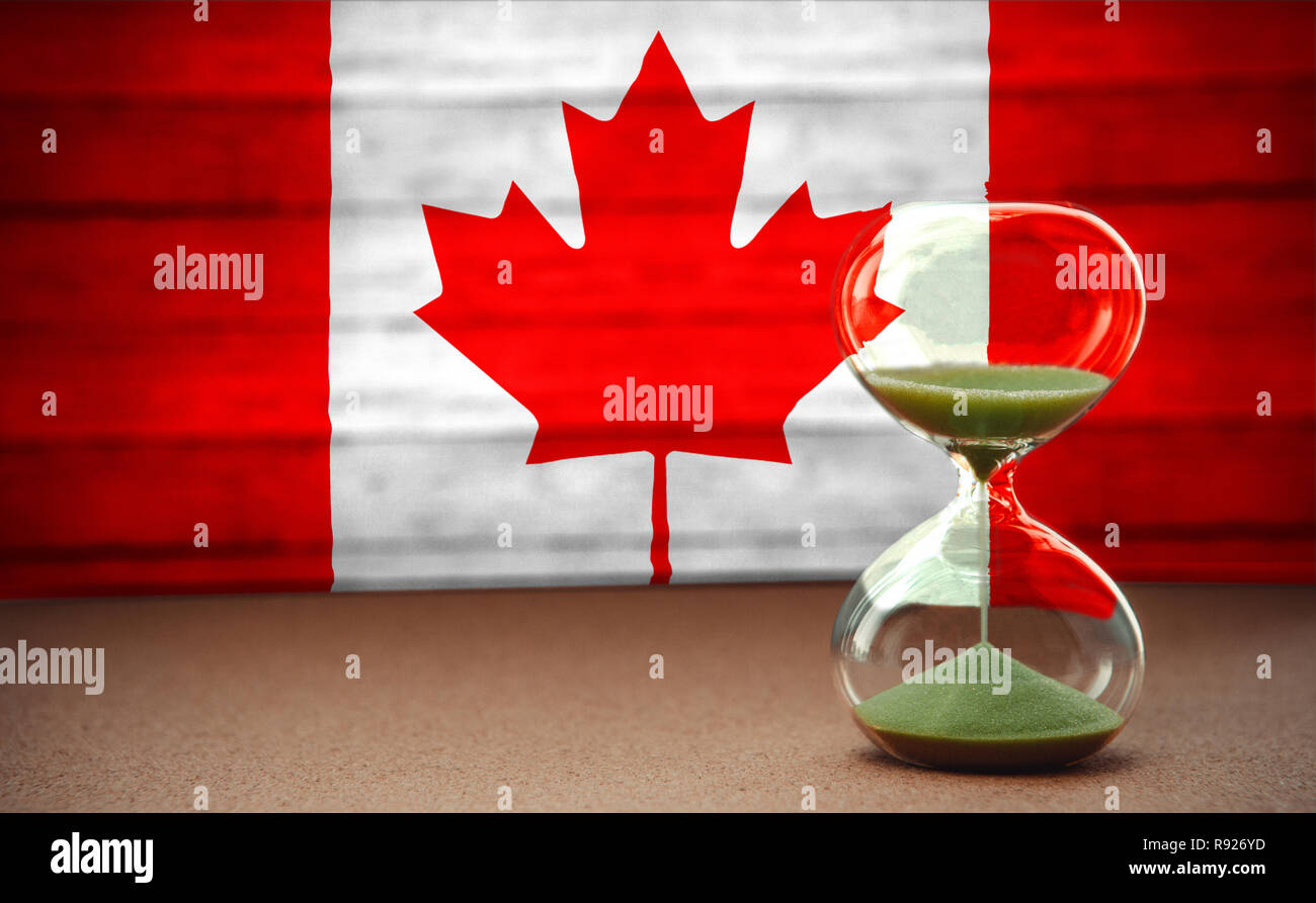 Hourglass on the background of the Canadian flag, the concept of time ...