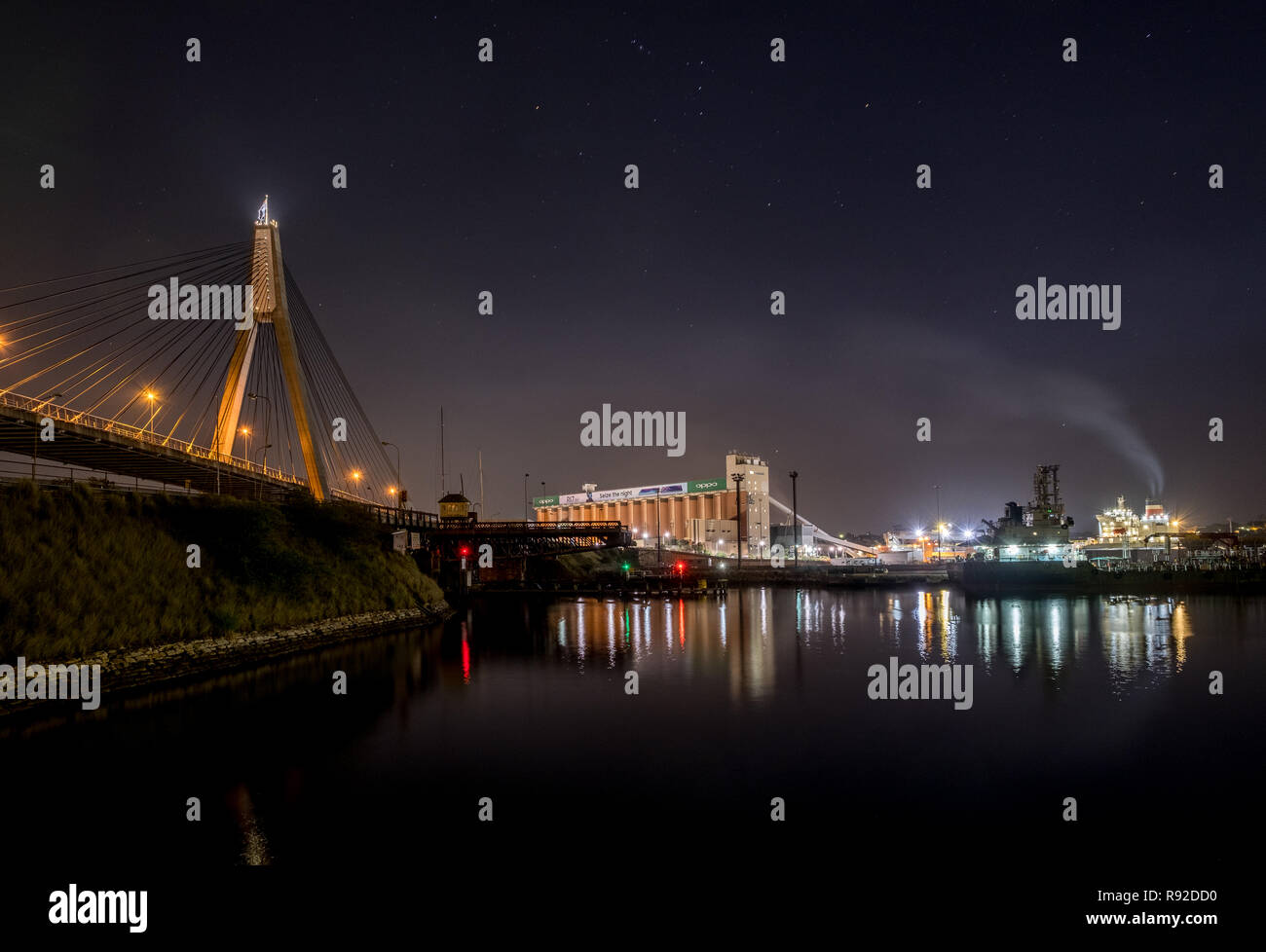 Bridge and concrete factory at night Stock Photo - Alamy