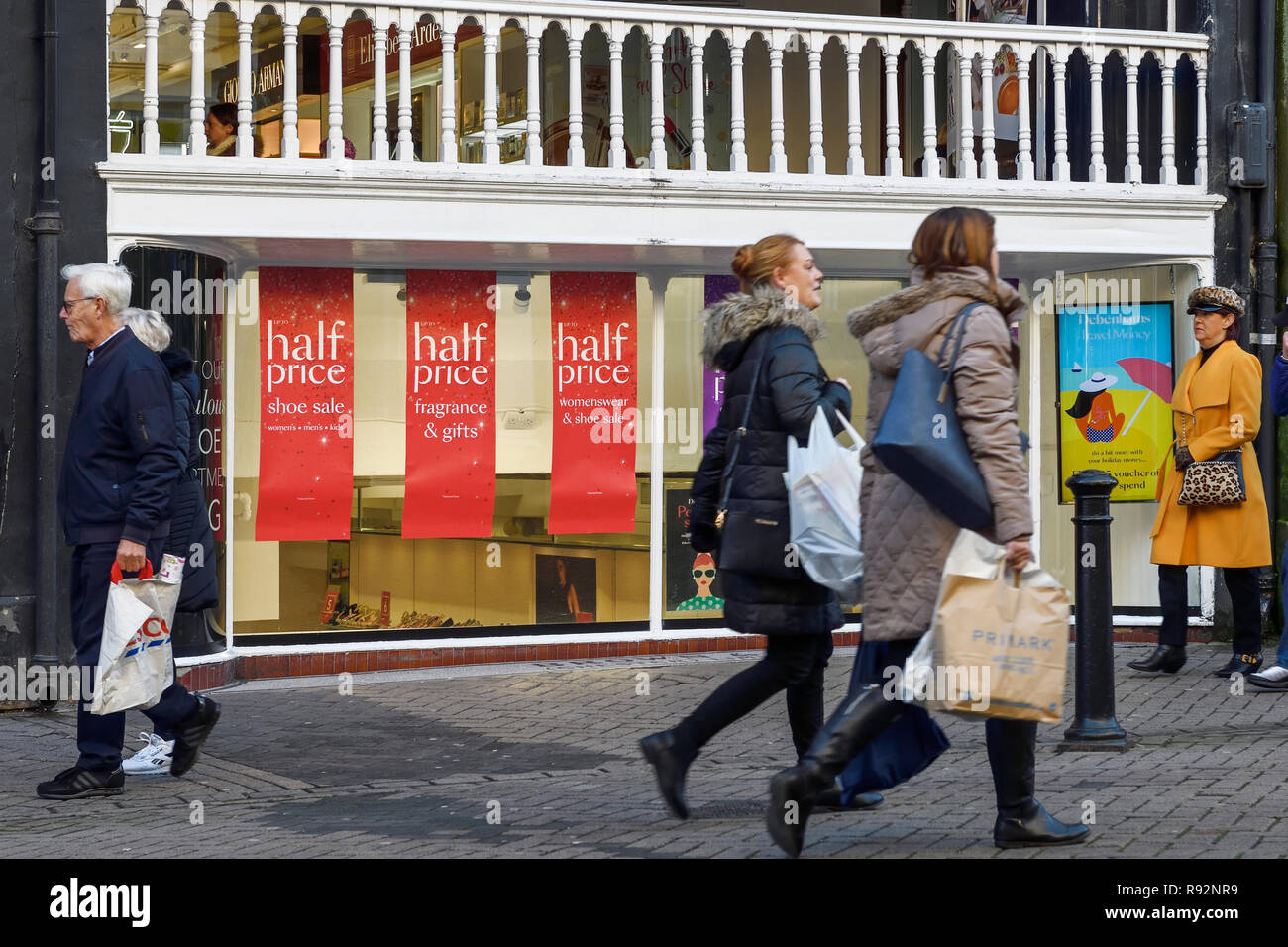 Chester, UK. 19th December 2018. Shoppers walk past city centre shop ...