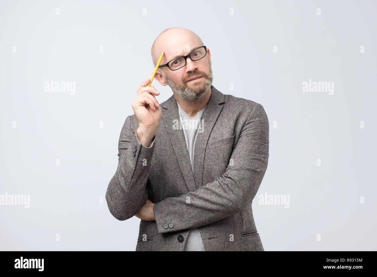 European man is thinking about something scratching his face with ...