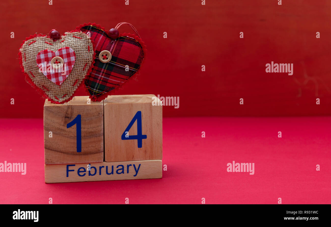Valentines day. Calendar wooden cubes with 14 February text and two red ...