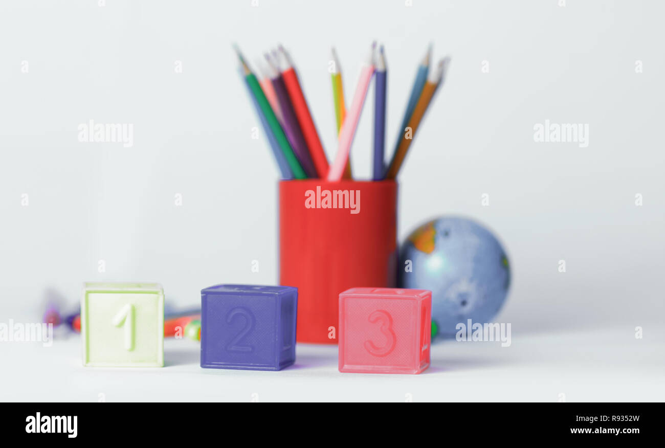 cubes with numbers on blurred school supplies background Stock Photo ...