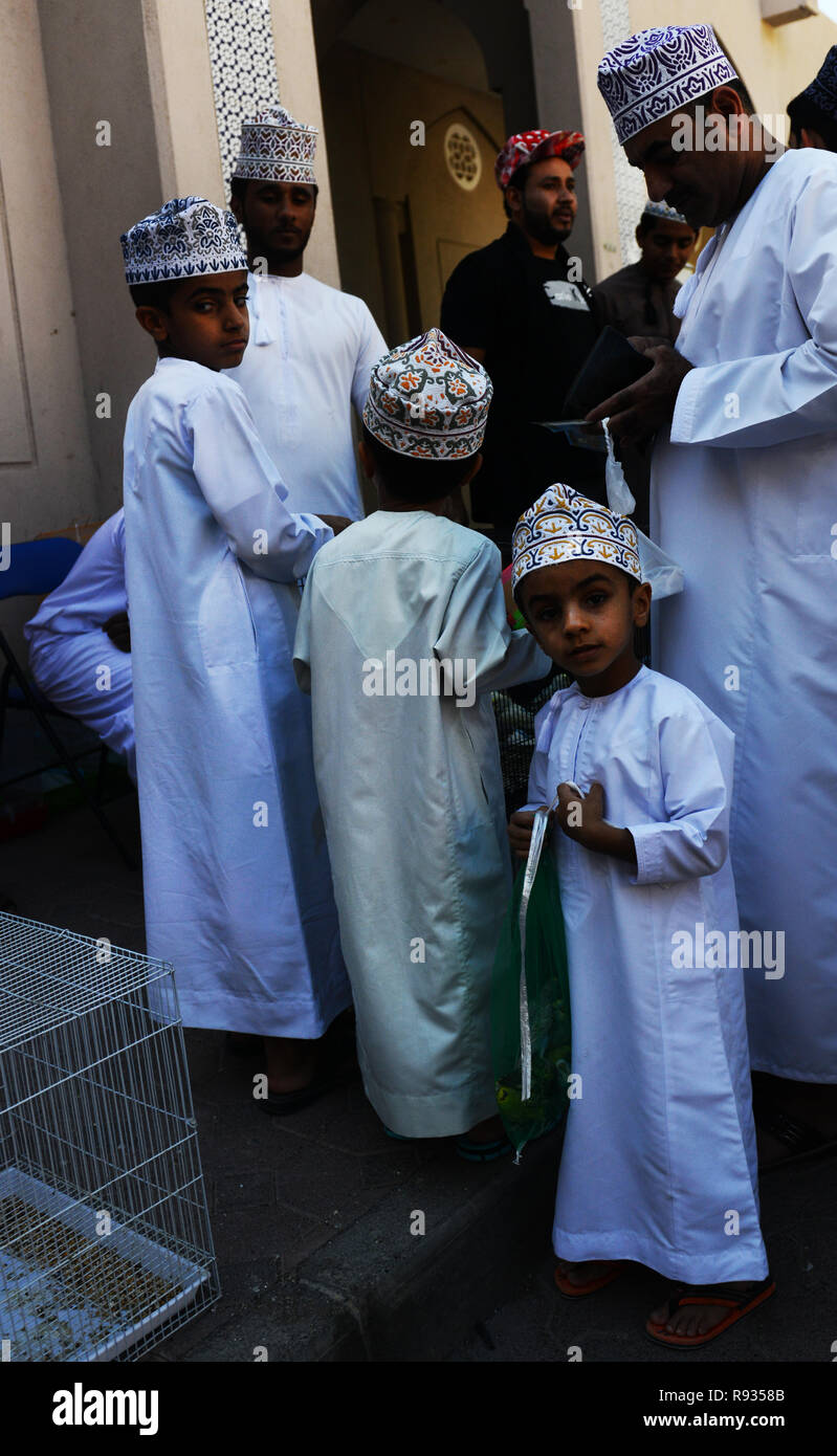 Omani boys wearing traditional Kuma caps and jalabiyas at the Friday ...