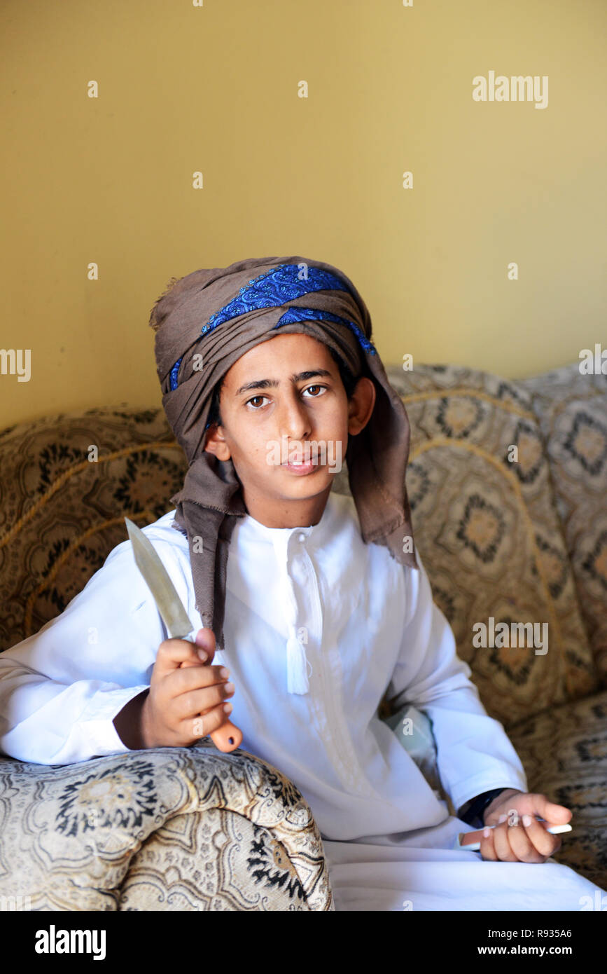 A traditionally dressed Omani boy holding his dagger Stock Photo - Alamy