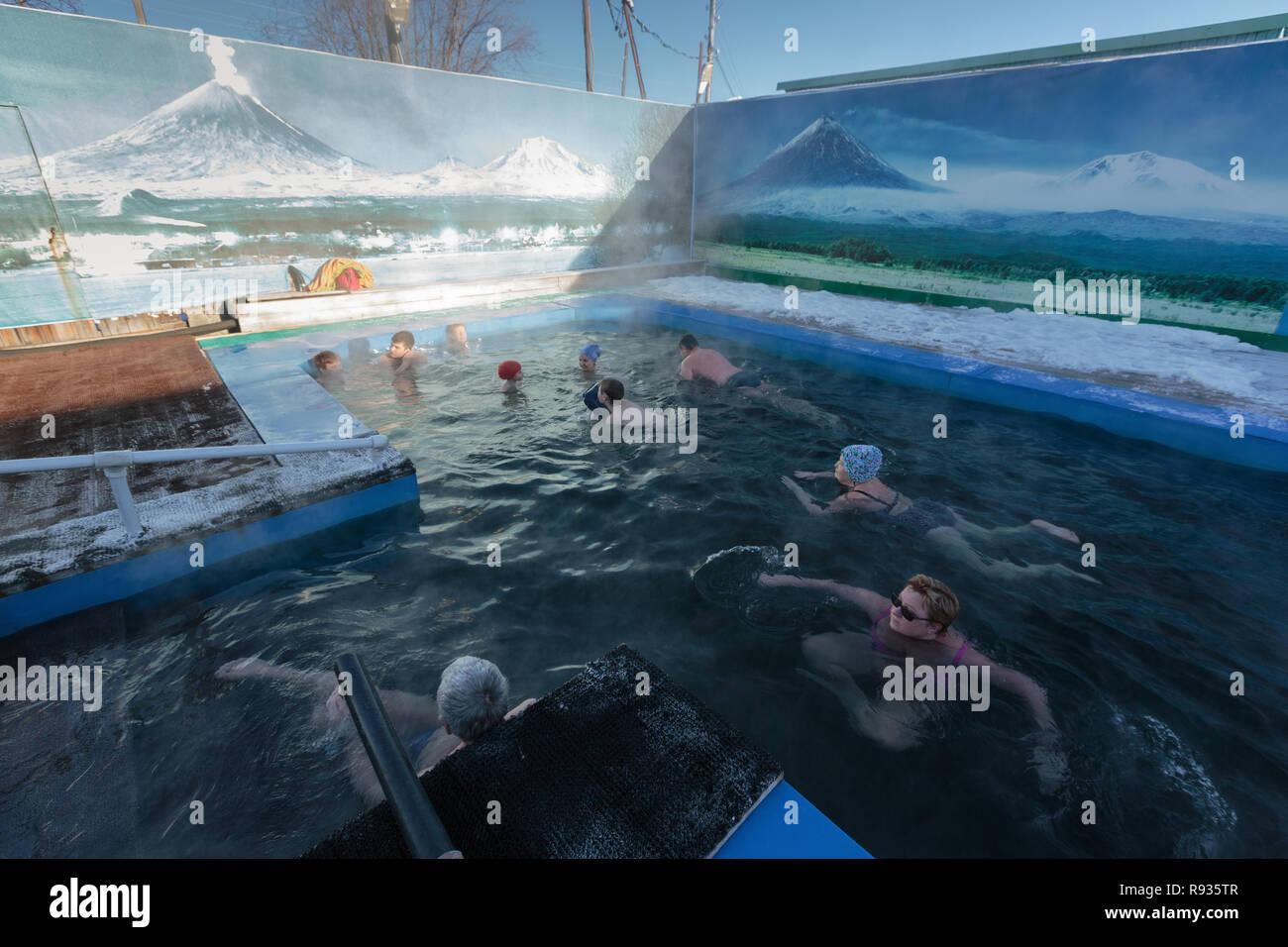 Group of people swimming in outdoors spa pool with natural thermal ...