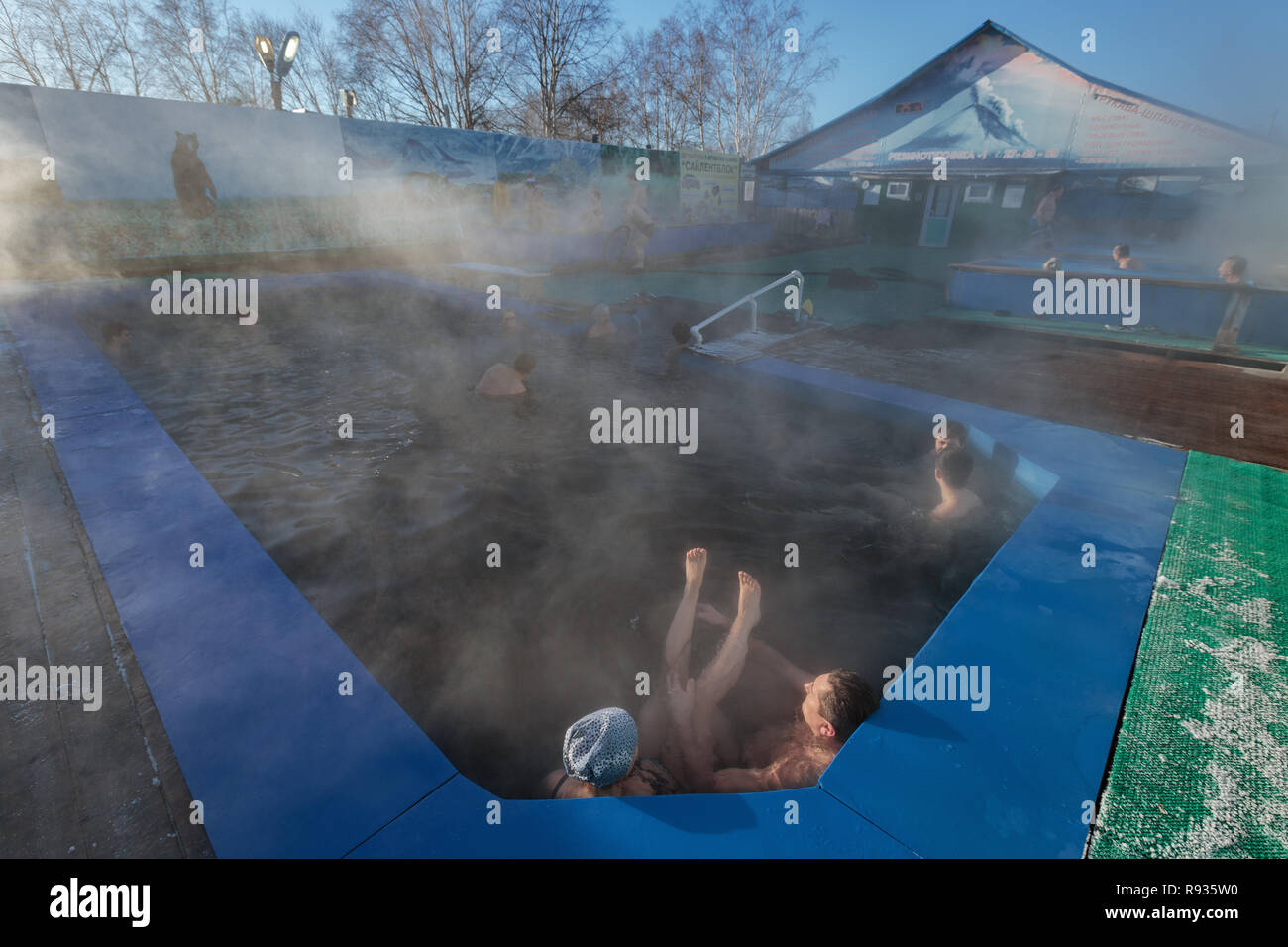 People relaxing in outdoors spa pool with natural thermal mineral water ...
