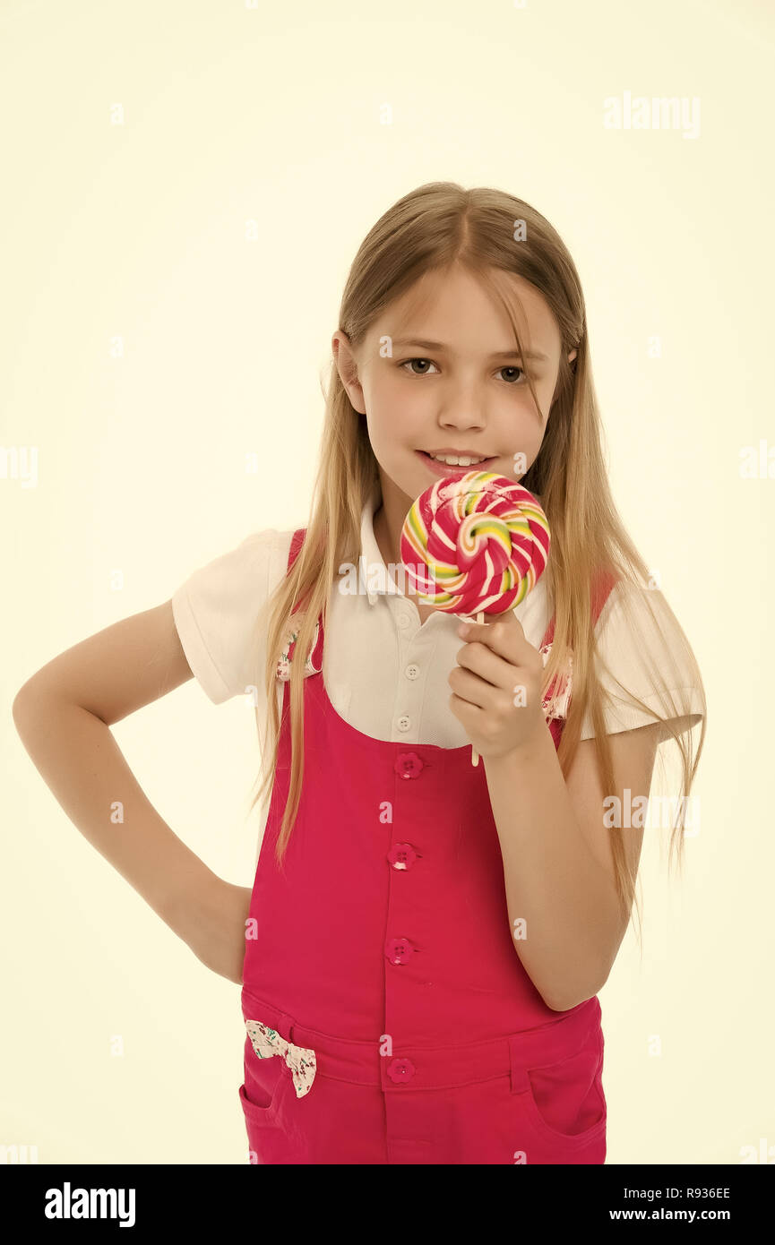 Sweet look. Little girl eat candy on stick isolated on white. Child ...