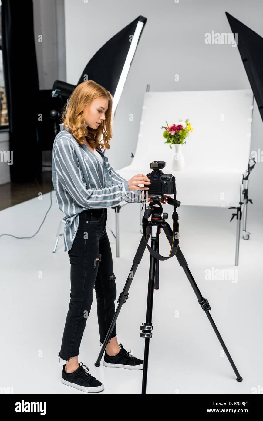 beautiful young female photographer shooting flowers in photo studio ...