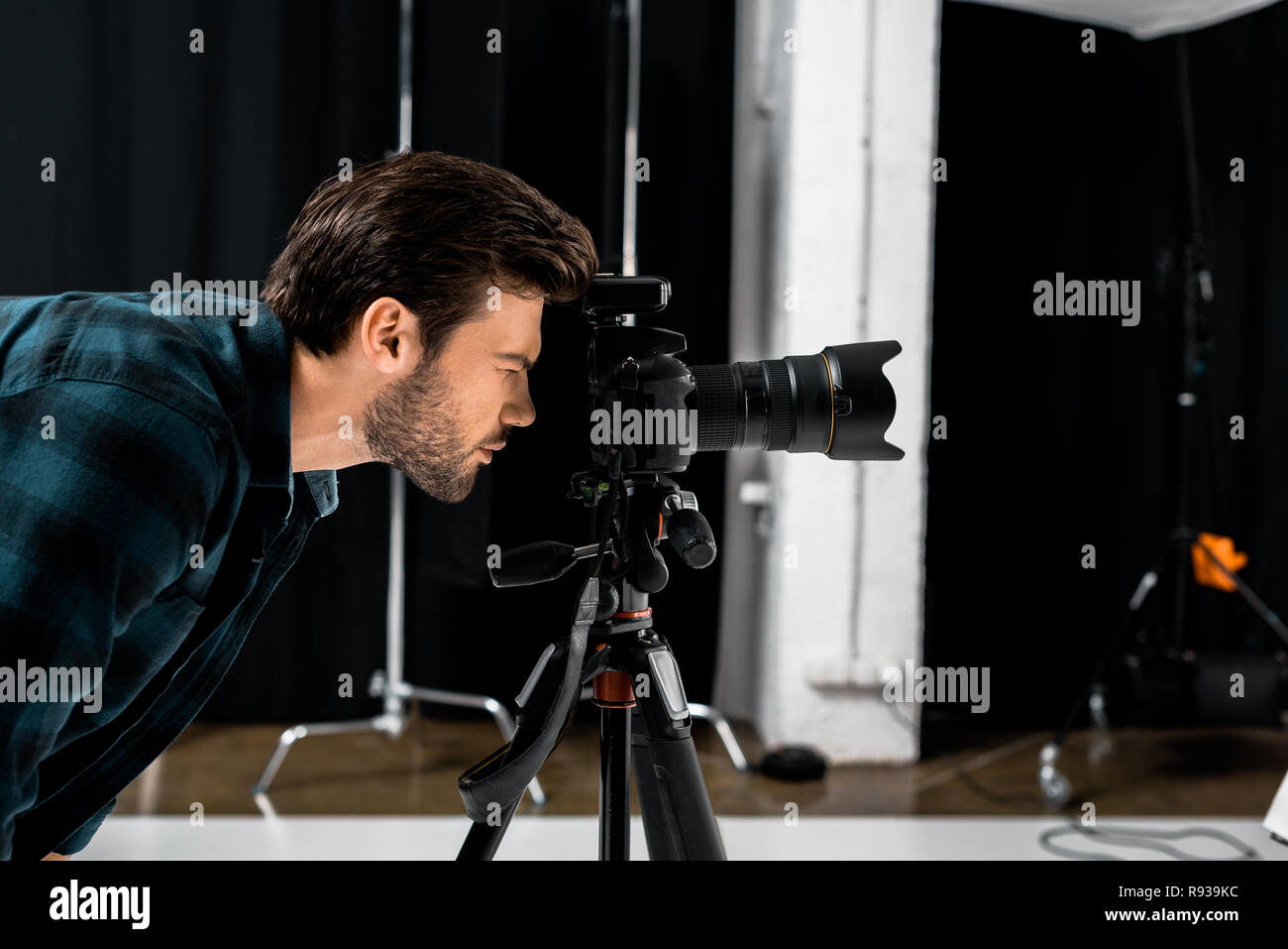 side view of young photographer working with professional photo camera ...