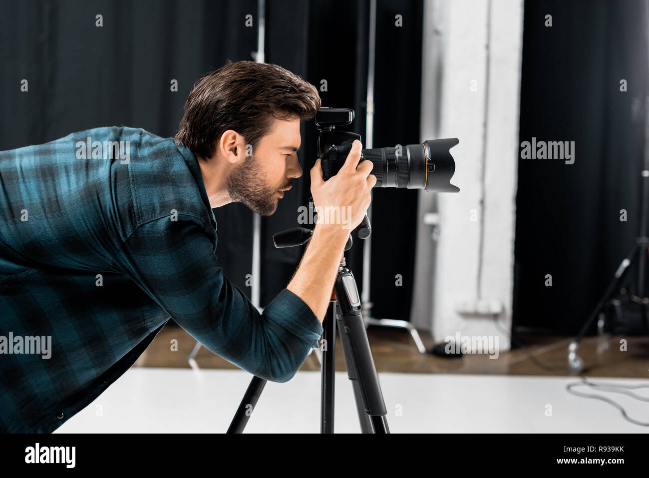 side view of professional young photographer working with camera in ...