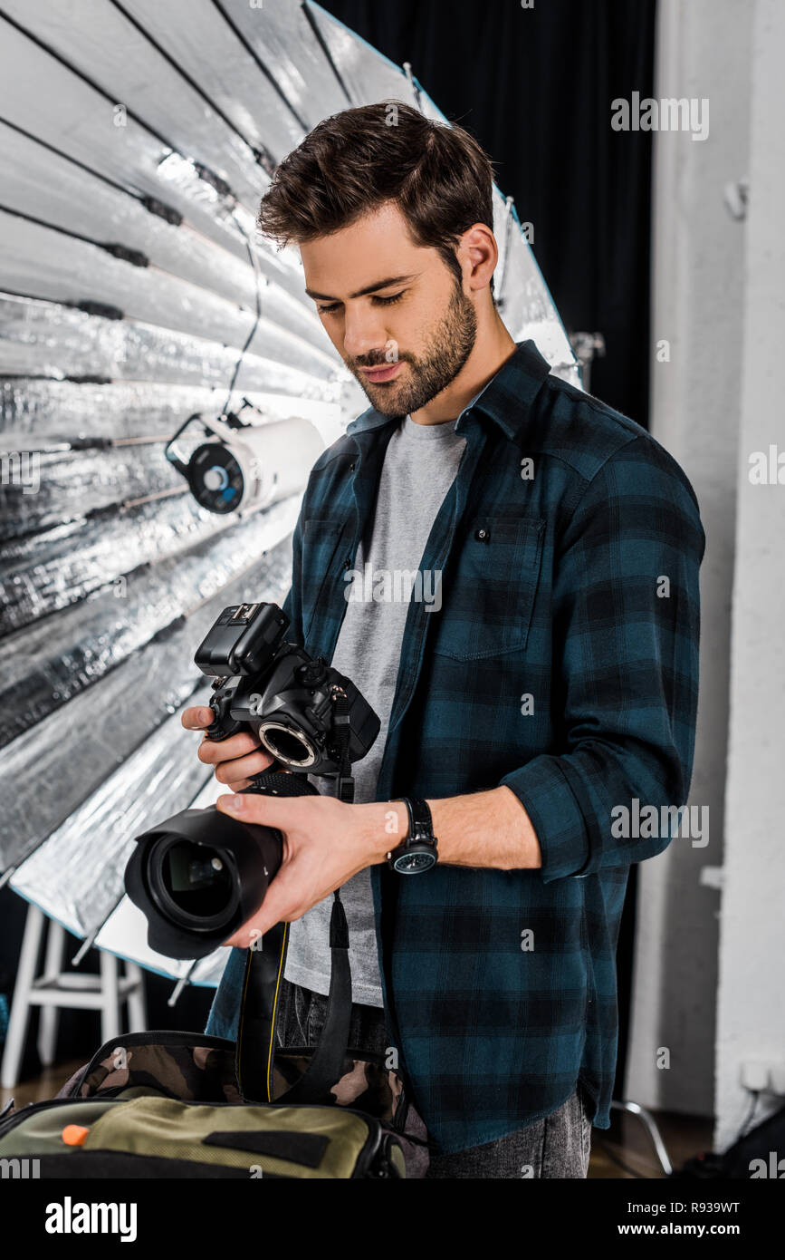 handsome young photographer holding professional photo equipment in ...
