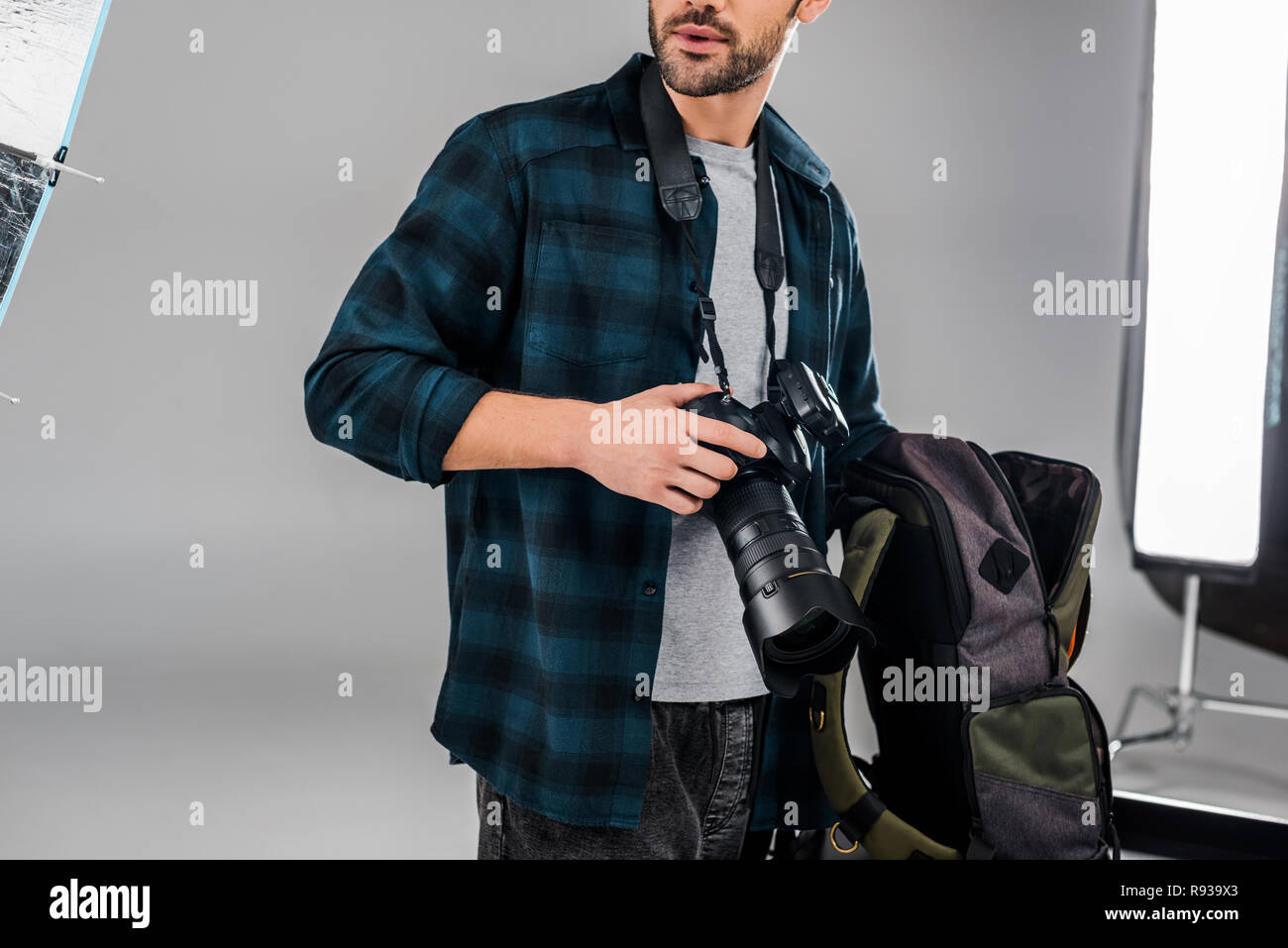 cropped shot of professional young photographer standing with photo ...