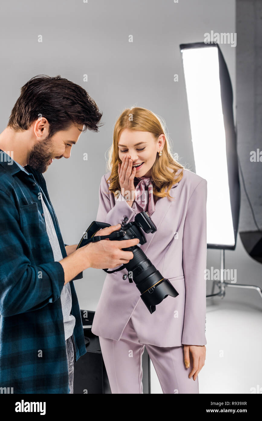 happy young photographer and model using photo camera together in ...
