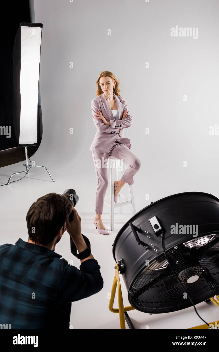 high angle view of young photographer shooting beautiful female model ...