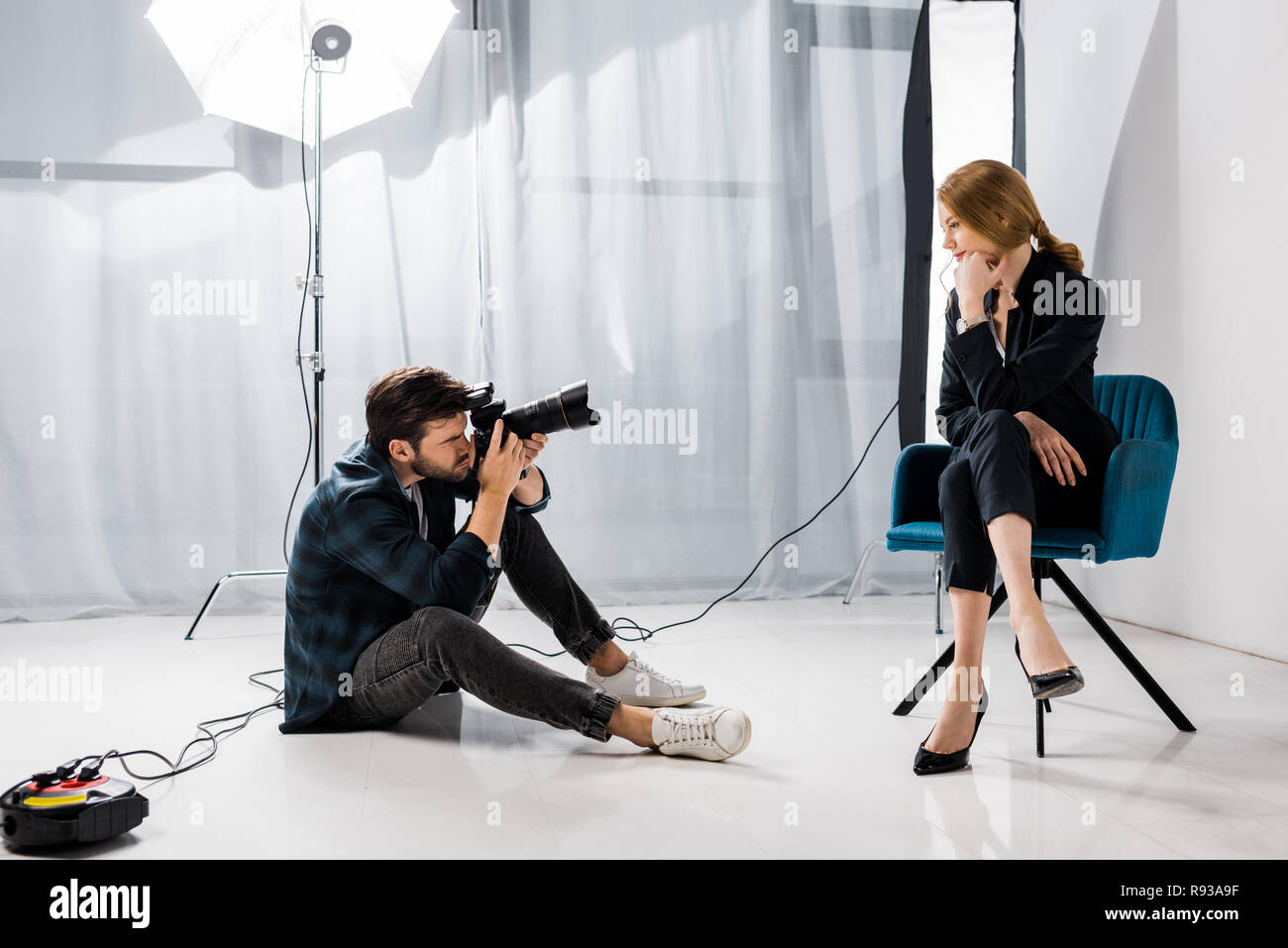 young male photographer shooting beautiful model in studio Stock Photo ...