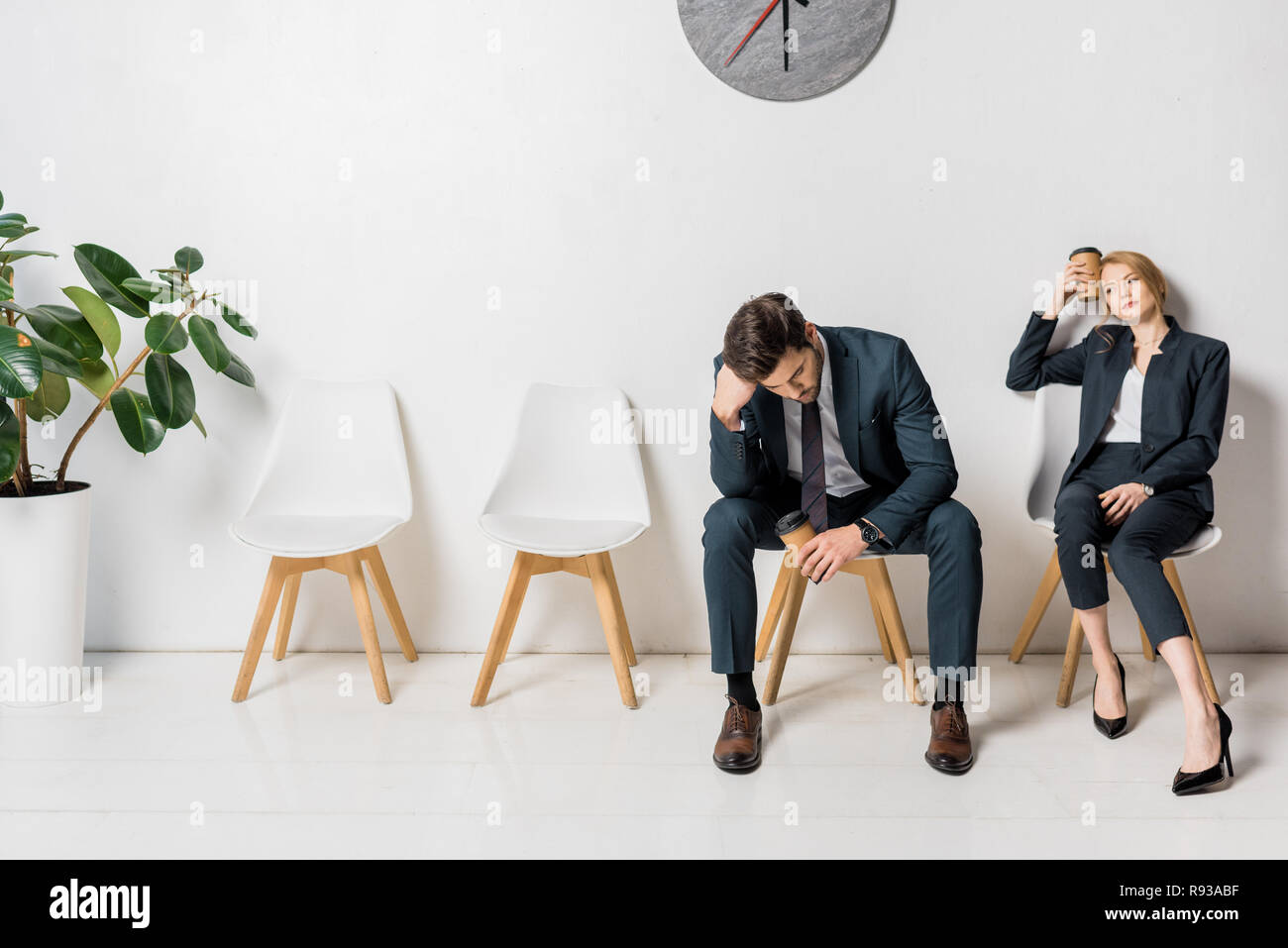 bored tired business people waiting on chairs in line Stock Photo - Alamy
