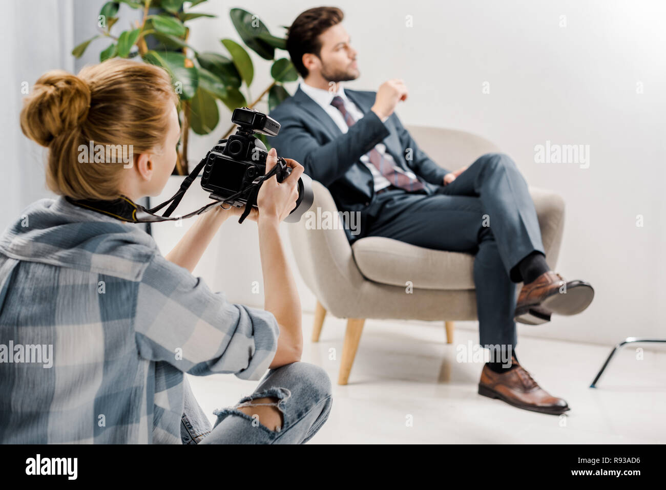 back view of young female photographer photographing handsome ...