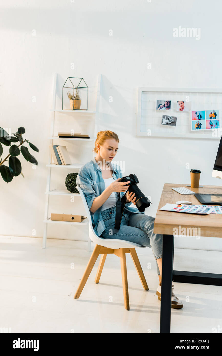 beautiful young female photographer using camera at workplace Stock ...