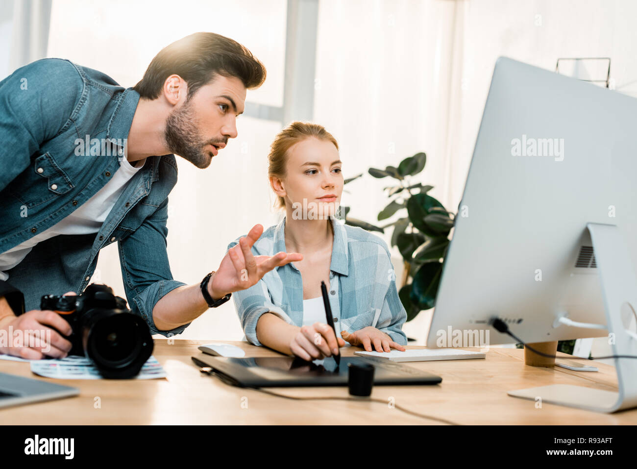 professional young photographers using digital devices and retouching ...