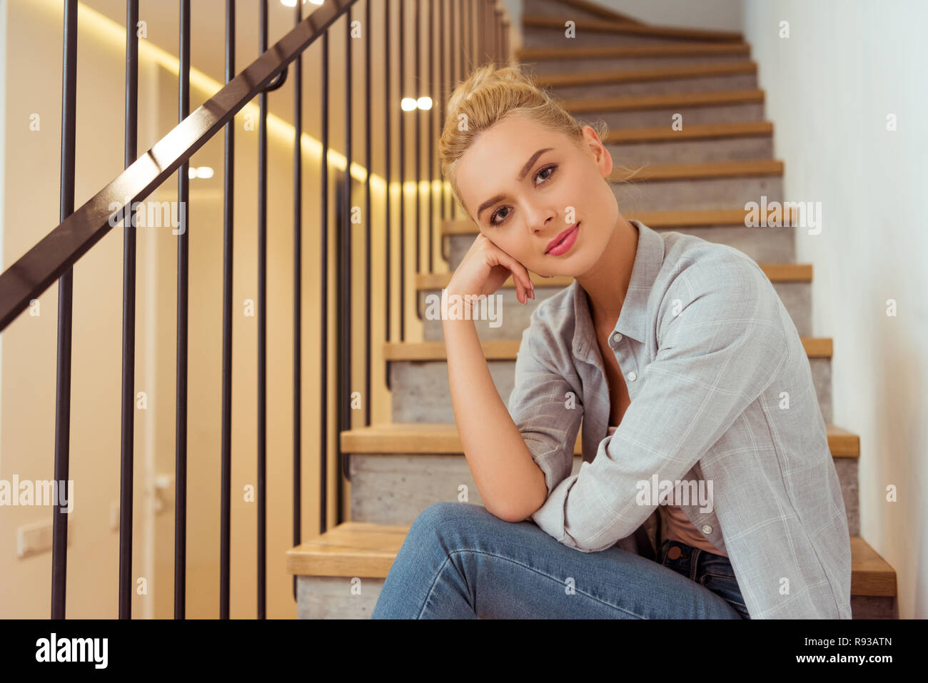 beautiful girl sitting on stairs and looking at camera Stock Photo - Alamy