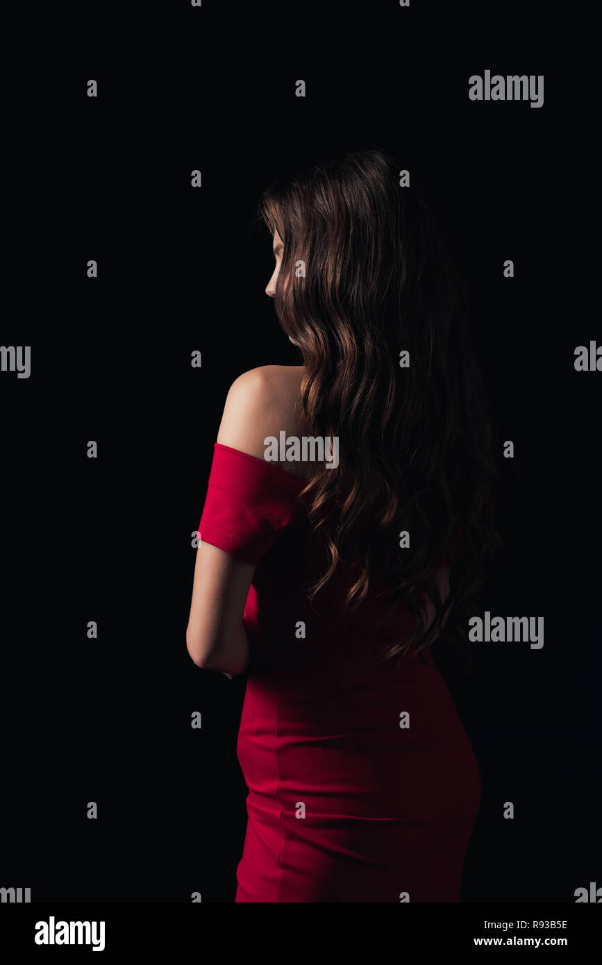 back view of woman in red dress posing isolated on black Stock Photo ...