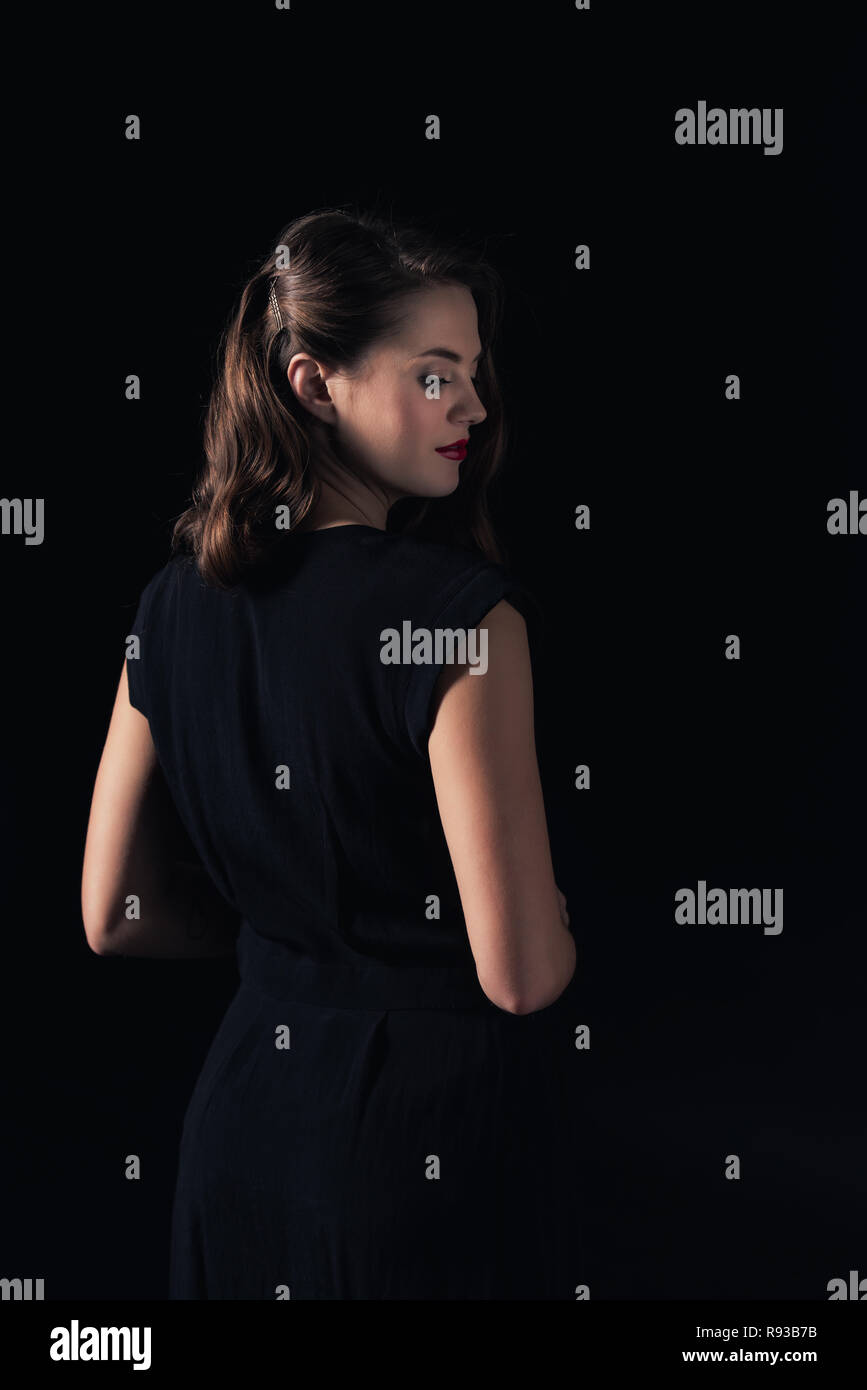 back view of beautiful woman in dress posing isolated on black Stock ...