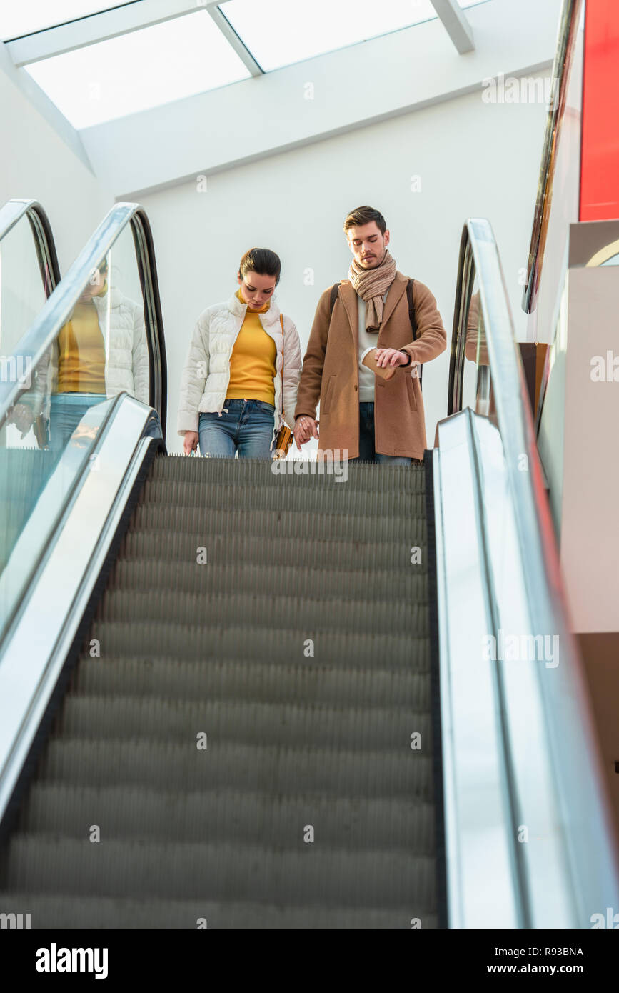 attractive girl and handsome man standing at top of escalator Stock ...