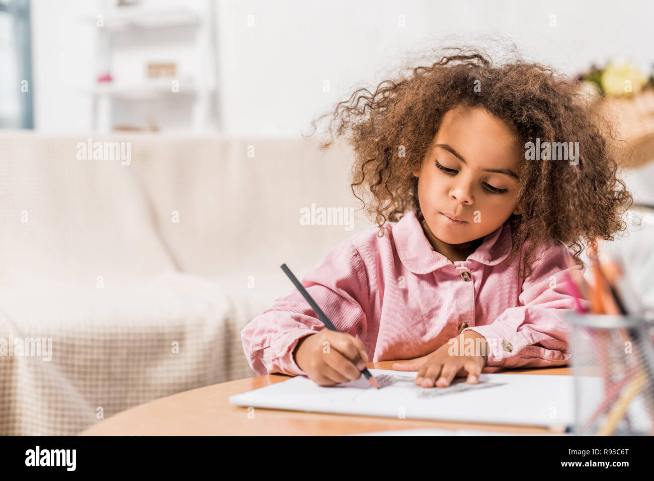 serious african american kid drawing on paper with color pencil in ...