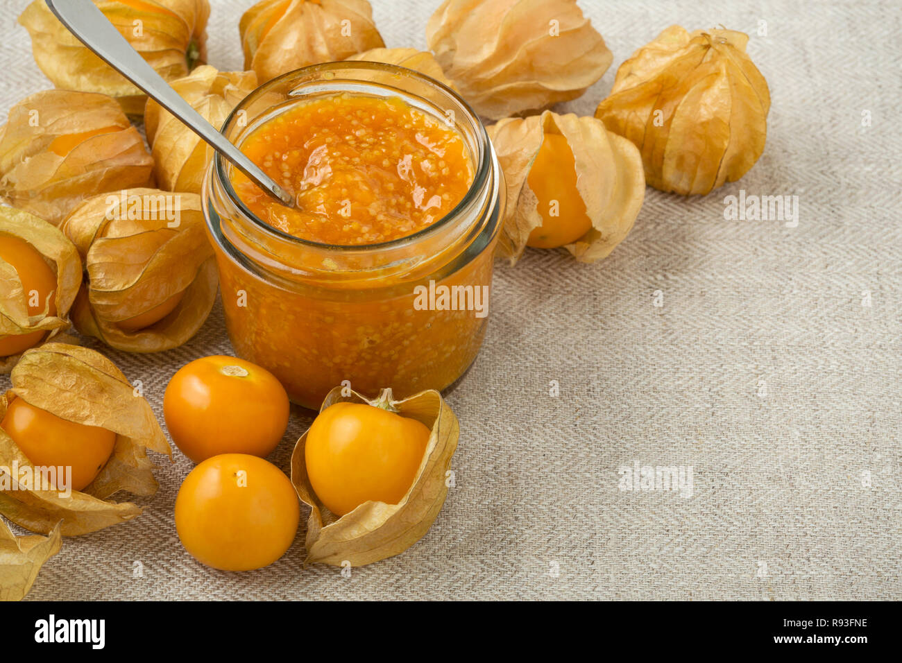 Golden berry jam in jar or cape gooseberries background with space ...