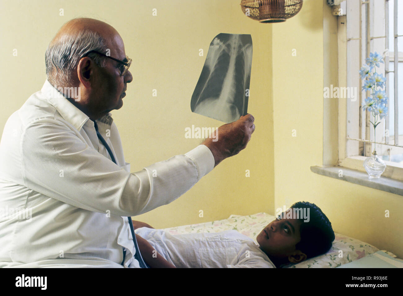 Indian Doctor checking x-ray of sick child MR#556 Stock Photo - Alamy