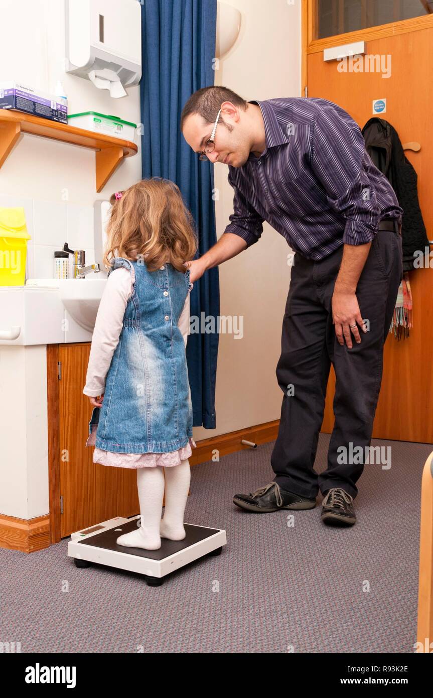 GP doctor's surgery, patient consultation, child being weighed, United ...